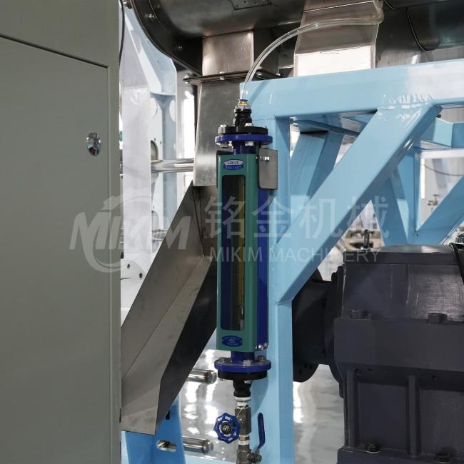 Industrial water pressure gauge and flow meter for precise moisture control in fish feed manufacturing.