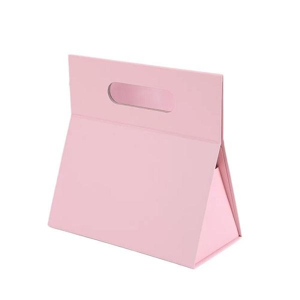 Close-up of die-cut oval handle and magnetic fold seam on pink paper gift box