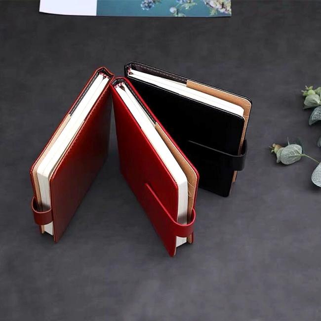Angled open view of red and black leather notebooks highlighting spine binding and inner page quality