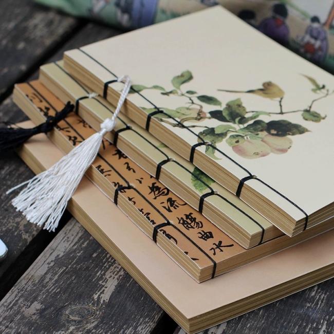 Stack of Chinese stab binding notebooks showcasing various covers, cords, and tassel colors