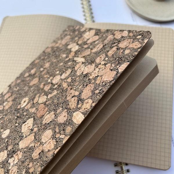 Open spread of the coffee cork notebook revealing clean grid-ruled internal pages and robust spine binding