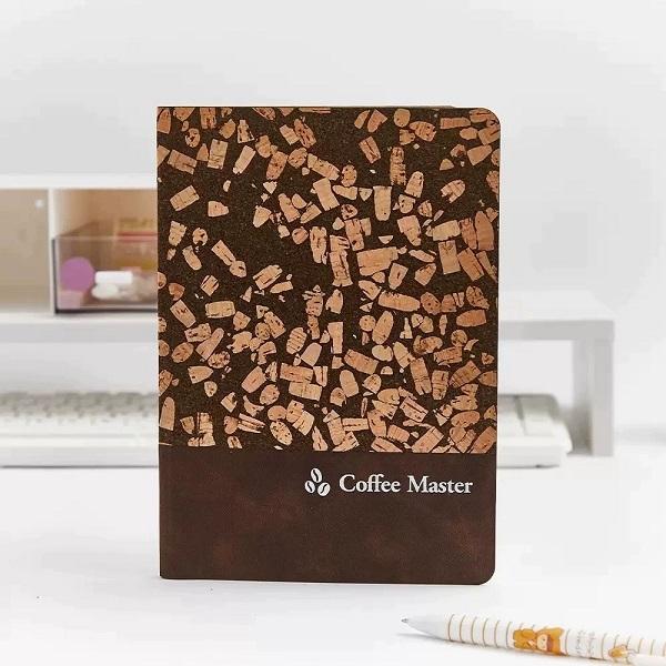 Office desktop display scene featuring the eco-friendly coffee cork notebook arranged alongside a matching patterned pen