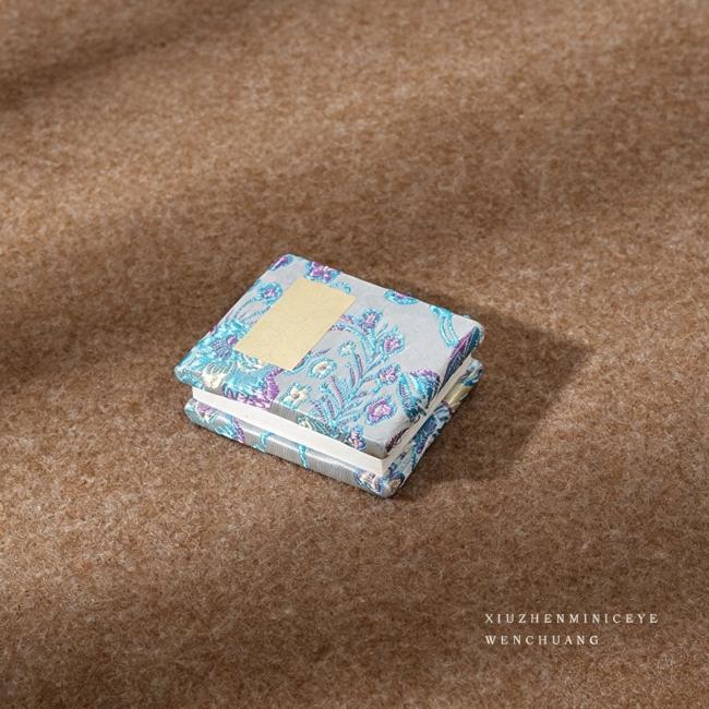 Blue and purple floral patterned brocade fabric mini accordion notebook showcasing vibrant traditional textile