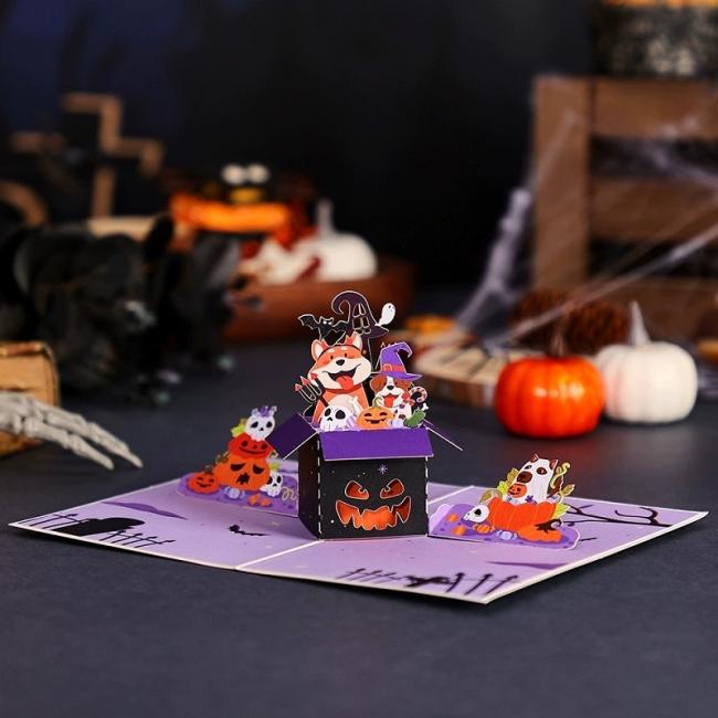 Angled perspective of expanded Halloween pop-up greeting card showing multi-layer paper sculpture and purple graveyard background