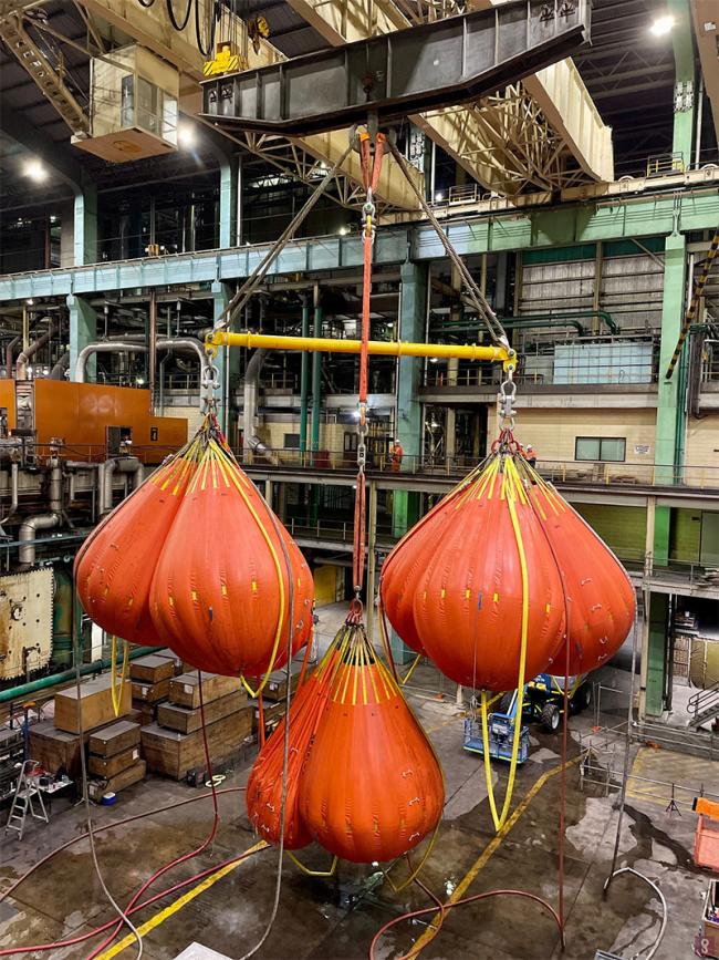 Load testing water bag filled with water suspended from a crane during proof load testing at a ship repair yard