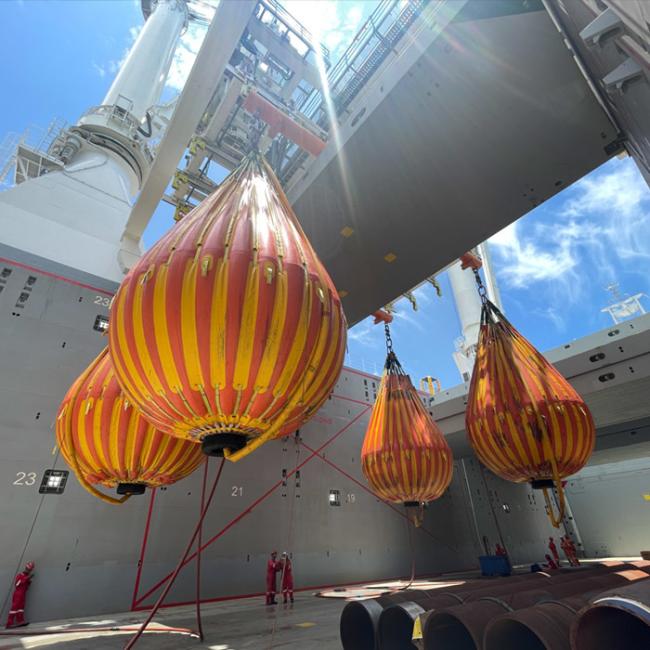 Filled load testing water bag connected to lifting rigging at an industrial test site