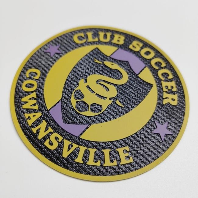 Close-up of embroidered heat transfer logo patch showing detailed stitching