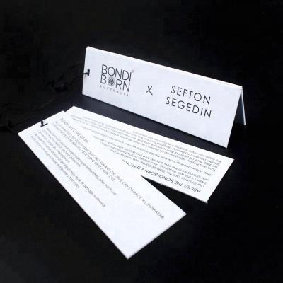 Cina Custom Name Offset Print Matte White Paper Hang Garment Label Tag with Care Instruction for Swimwear in vendita