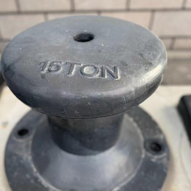 Close-up view of a fixed mooring bollard on a quay structure