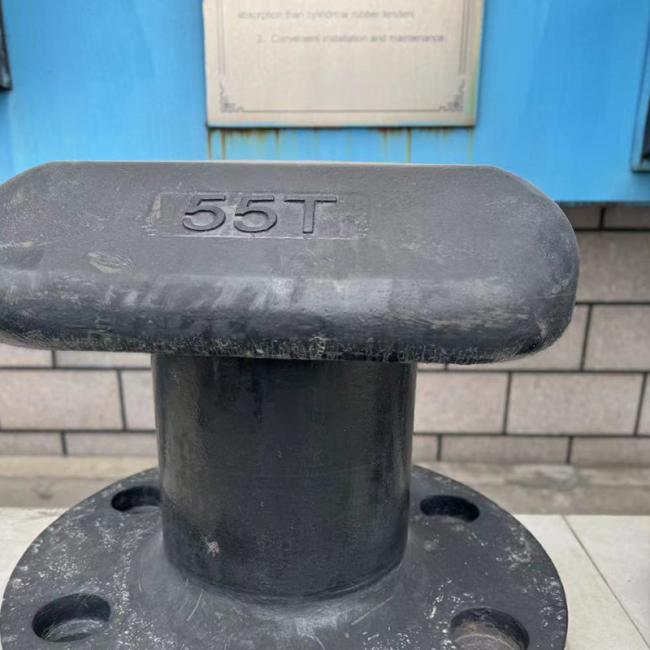 Close-up view of a marine mooring bollard with protective surface coating at a coastal facility