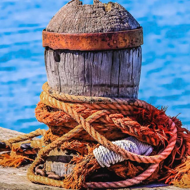 Mooring bollard installed at an industrial port berth, showing the bollard body and mounting base