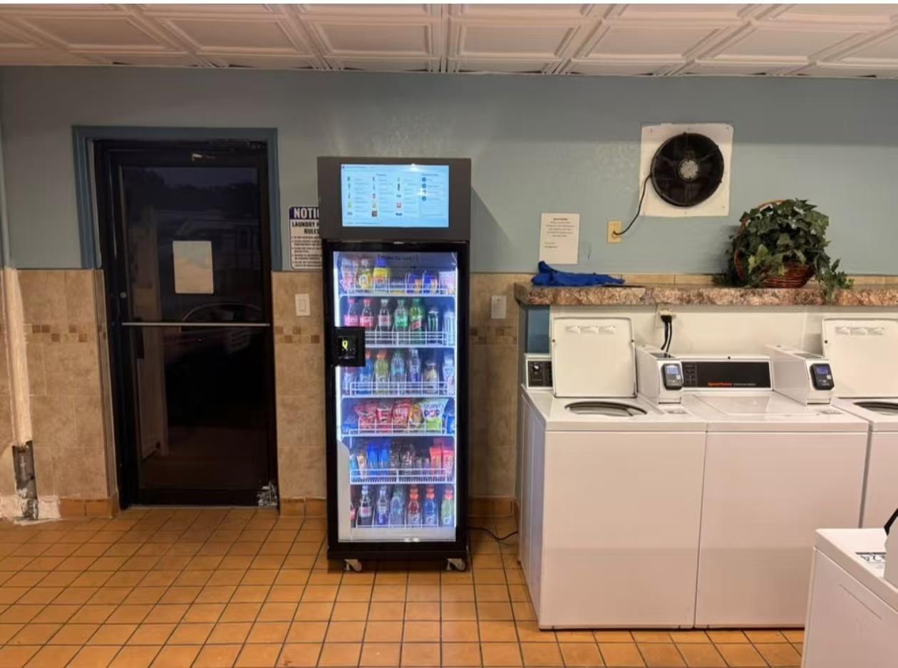 Smart AI vending machine operating in a US laundromat selling cold drinks and snacks via smart fridge vision technology