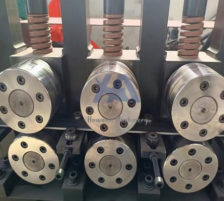 Close-up of Howann CNC clamp making machine tooling station with CR12MOV alloy steel feeding wheels and bending molds