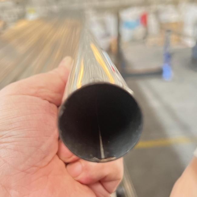 `Close-up view of mirror polished stainless steel round tube, smooth interior and shiny surface for handrail`