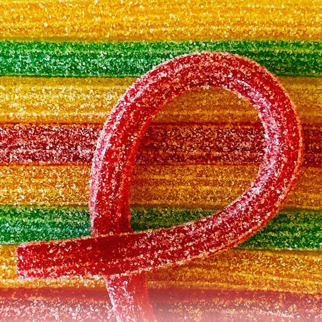 Close-up view of pink sugar coated sour straw candy
