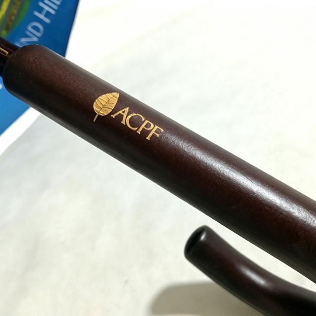 Close-up view of laser-engraved logo on wooden umbrella handle
