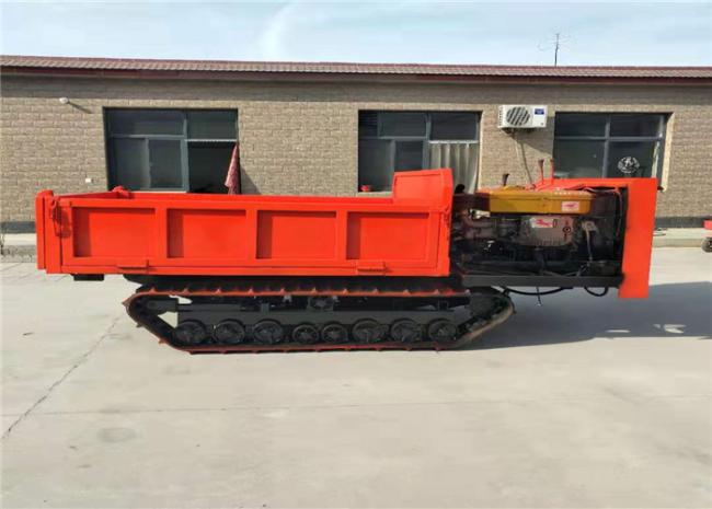 Red 4x4 Crawler Transporter in operation showing its track system and bucket container