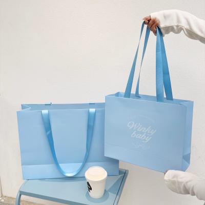China Luxury Boutique Tote Premium Light Blue Clothing Gift Bag Custom Logo Printing Reinforced Ribbon Handles for sale