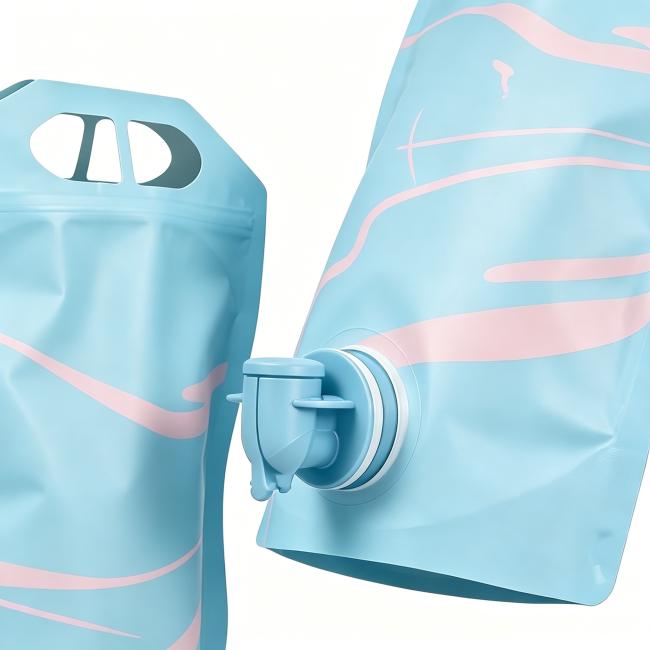 Partial close-up of two wine pouches focusing on the tap fitting structure. Clearly shows the thickened sealing ring, outer plastic collar and flip tap connector, reflecting durable leak-resistant connection design for repeated pouring use.