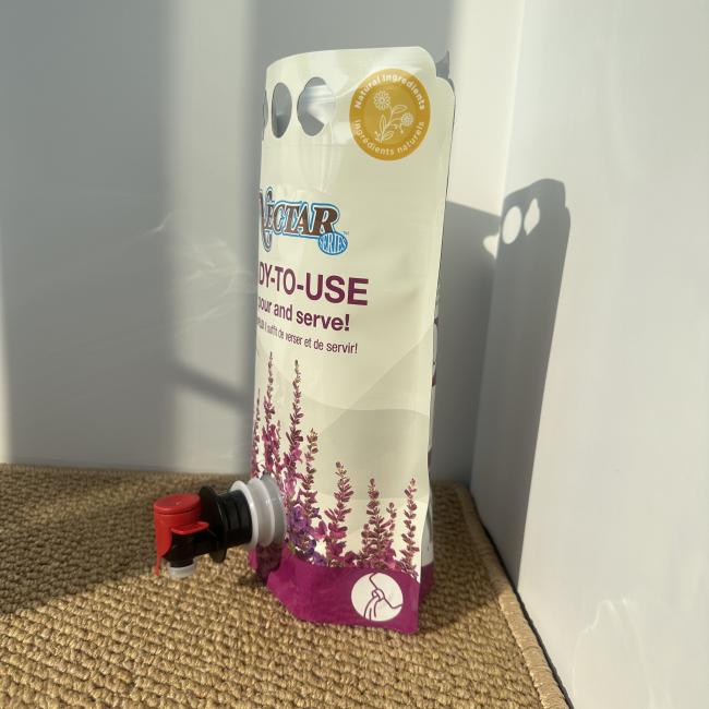 1.5L hummingbird nectar spout pouch, printed flexible bag with red dispensing tap and carry holes`