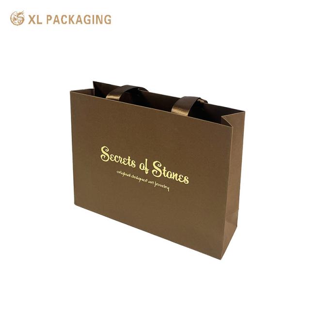 Luxury brown paper gift tote bag with gold foil logo and satin ribbon handles