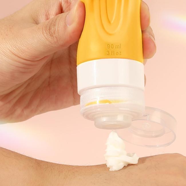 Silicone travel bottles being filled using included funnel