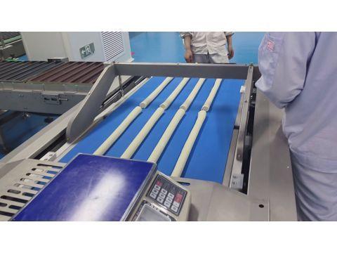 An automatic retracting belt panning machine placing divided dough pieces accurately onto baking trays based on customized pan sizes.