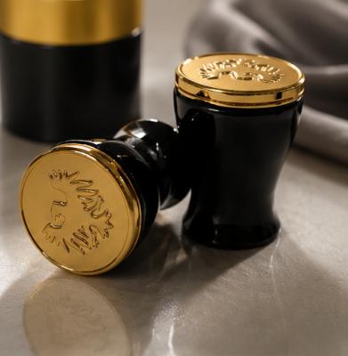 China Custom Embossed Logo Zamac Perfume Cap with Hourglass Waisted Design and Black & Gold Finish for sale