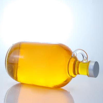 Cina Logo personalizzato Bottiglia di vetro di liquore a forma rotonda con manico e tappo a vite in vendita