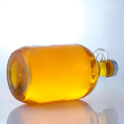 Cina Logo personalizzato Bottiglia di vetro di liquore a forma rotonda con manico e tappo a vite in vendita