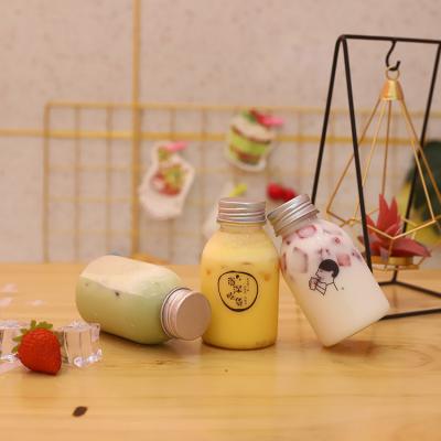 China Plastic Milk Tea Bottles Featuring Handle and Screw on Lid Beverage Packaging Solutions with Comfortable Handling for sale