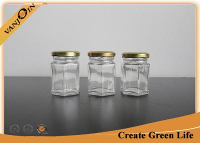 Cina Barattoli di vetro esagonali di trattamento di superficie dell'alimento di 2oz 60ml i piccoli con i coperchi/ansa ricoprono il diametro di 43mm in vendita