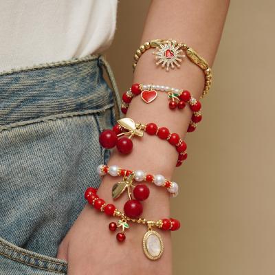 Cina Braccialetti con ciondoli e perline Collana Oro Rosso Impermeabile Ottone Placcato Oro Braccialetti con Perline e Ciondoli in vendita
