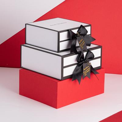 中国 Rigid White Magnetic Cardboard Gift Boxes With Black Rim And Ribbon Bow 販売のため