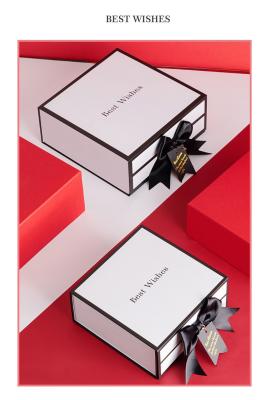 中国 Rigid White Magnetic Cardboard Gift Boxes With Black Rim And Ribbon Bow 販売のため