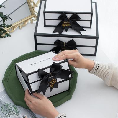 中国 Rigid White Magnetic Cardboard Gift Boxes With Black Rim And Ribbon Bow 販売のため