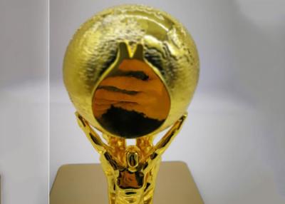 China Shiny Gold Plated Custom Trophy Cup With The Statue Holding The Ball Design for sale