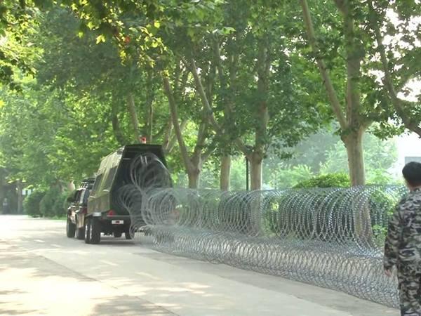 A trailer is deploying razor wires.