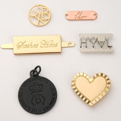 China Engraved Embossed Name Tag Design Gold Custom Metal Logo For Sewing Clothing Tag Te koop