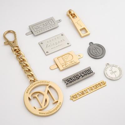 China Engraved Embossed Name Tag Design Gold Custom Metal Logo For Sewing Clothing Tag Te koop
