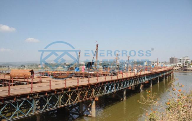 Completed Bailey bridge installation showing full span and traffic use