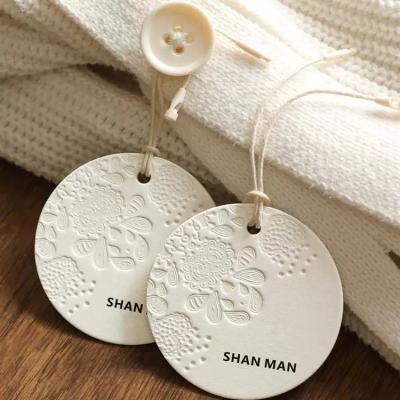 China Custom OEM Embossed Round Clothing Hang Tags with 250gsm-400gsm Premium Textured Art Paper for Fashion Brands for sale
