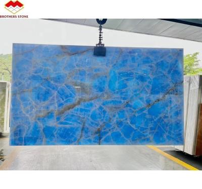 China Natuurlijke doorschijnende blauwe onyxsteenplaat voor tv-achtergrondwandpaneel in goudblauw Te koop