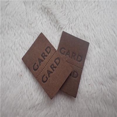 China Embossed Leather Woven Label With Dashed Points Convenient To Mid Fold for sale