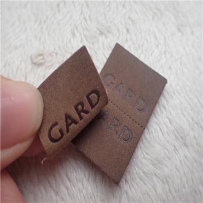 China Embossed Leather Woven Label With Dashed Points Convenient To Mid Fold for sale