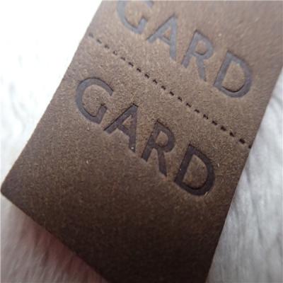 China Embossed Leather Woven Label With Dashed Points Convenient To Mid Fold for sale