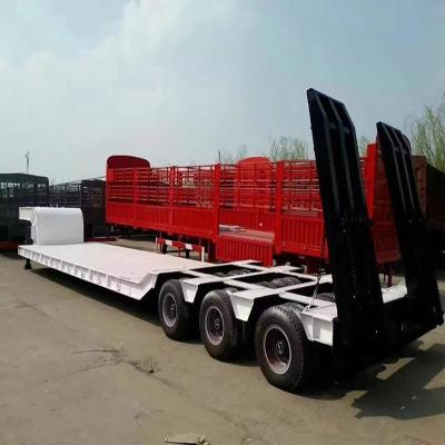 China Zware 50 ton maximale lading 3 assen laagbed semi-truck aanhangwagen stalen standaard 28 ton Te koop