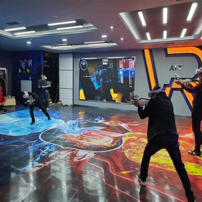 Multiplayer VR Arena Simulator showing players in action with VR headsets and weapons