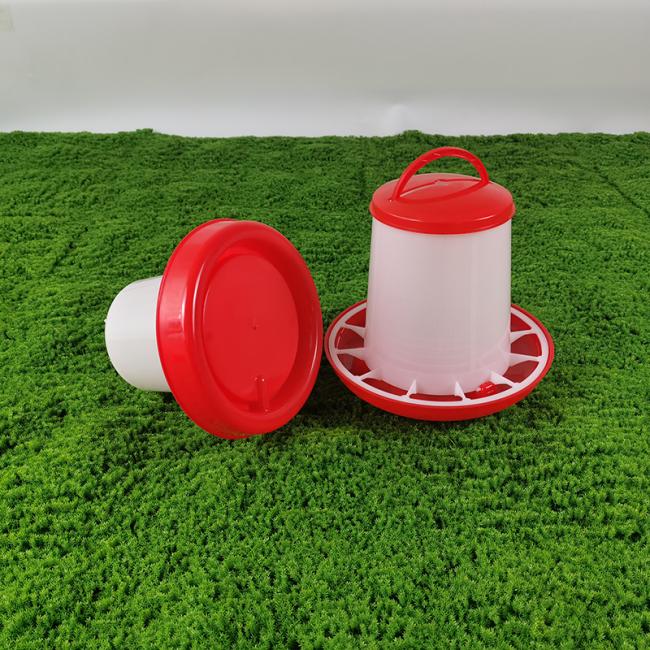 Red and white poultry feeder in use with chickens