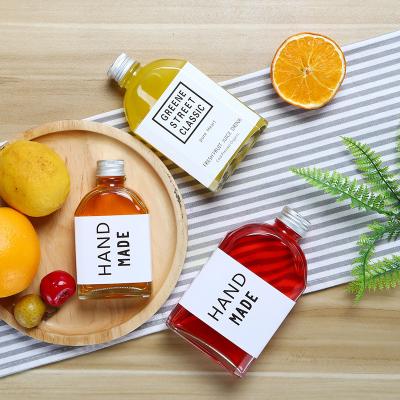 Cina bottiglia di vetro spessa della bottiglia di vino di 350ml Juice Glass Drinking Bottles Flat con il coperchio in vendita